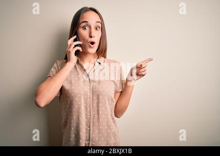 Surprised woman talking by phone, great news, open mouth, wow. Young ...