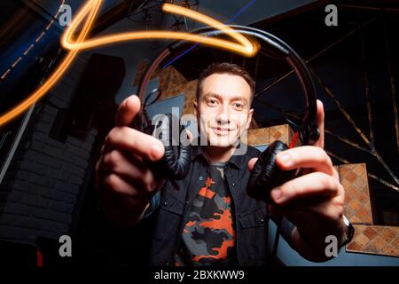 The face of a man with emotions. DJ puts on headphones. Young emotional ...