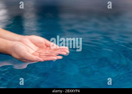 Closeup image of a hand splashing water in the pool Stock Photo - Alamy