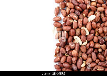 peeled peanuts sprinkled on a white background. nutritious vegetable ...