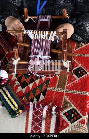 A senior arabian woman makes a traditional sadu weaving. Hands of a ...