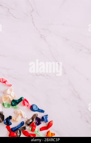 Flat lay of deflated water ballons against a marble background with ...