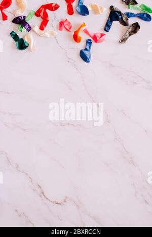 Flat lay of deflated water ballons against a marble background with ...