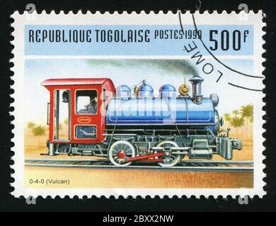 TOGOLESE REPUBLIC -CIRCA 1999: Ancient train with a steam locomotive ...