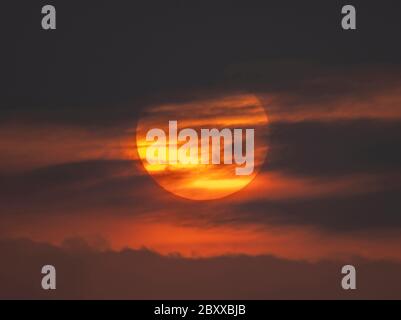The setting sun is visible behind a new building with a crane in Berlin ...