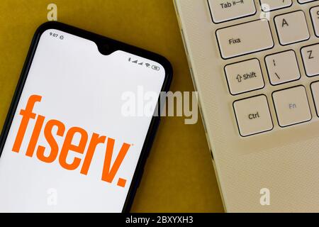 In this photo illustration, the Fiserv logo is seen displayed on a ...