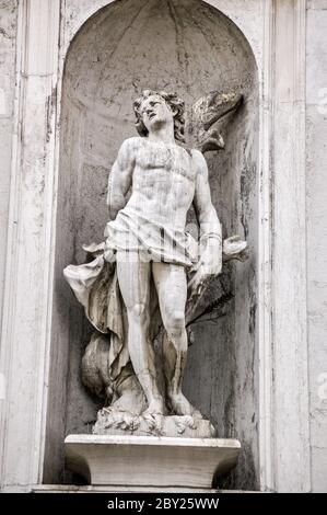 Carved stone statue of St Sebastian, martyred by being shot with arrows ...