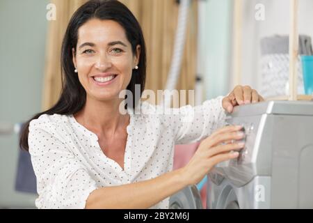 Woman Doing Laundry Reaching Inside Washing Machine Stock Photo - Alamy
