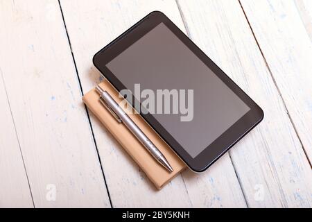 Tablet with notebook on shabbi white wooden table and pen Stock Photo ...