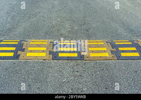 Street speed bump in the road for safety painted with yellow color ...