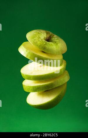 floating green apple cut in half by knife on white background Stock ...