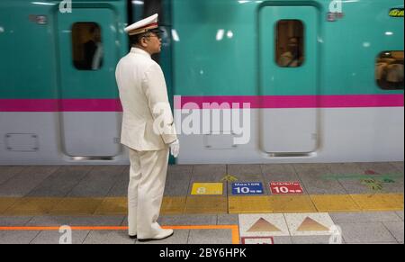 Station master conductor at Shinkanse platform terminal in Tokyo ...