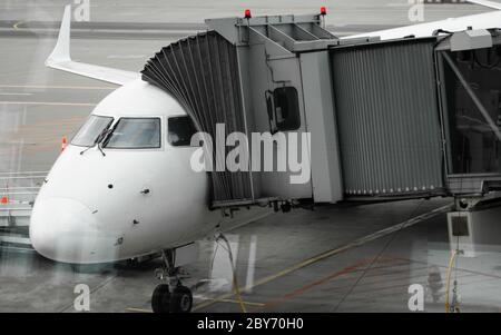 Jetway connected to the airplane for boarding passengers. Boarding ...