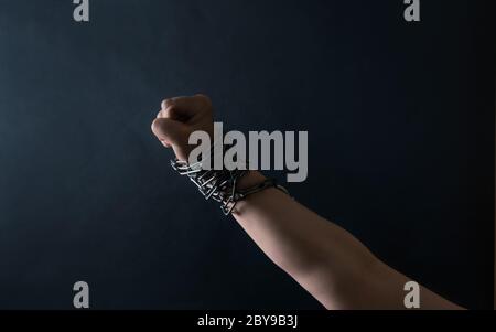 Fist of Hand are chained in chains on the black background, concept of ...