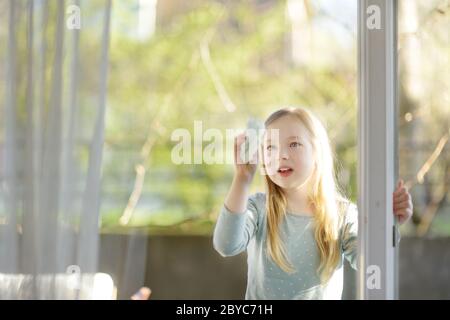 Little girl washing a window. Kids clean the house. Children help at ...