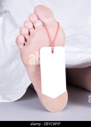 Studio shot of a dead body with a toe tag isolated on white background ...