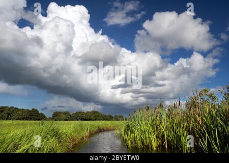 dramatic clouds over the river in misty morning in spring with ...