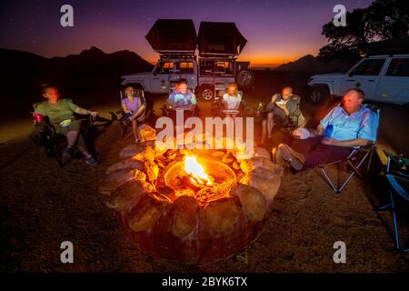 Everyone gathering around the campfire for a hot meal and some ...