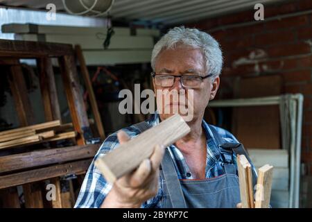 Old carpenter checking the wood planks Stock Photo - Alamy