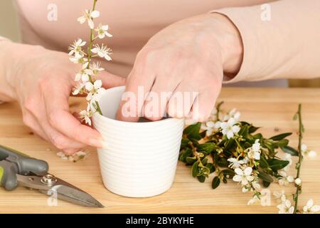 Florist at work: woman shows how to make a simple decoration with ...