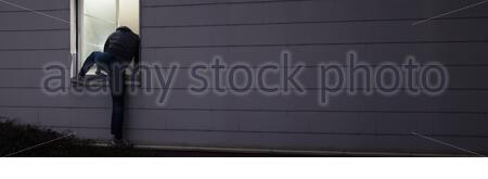 A burglar climbing through a window Stock Photo - Alamy