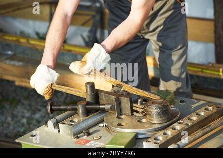 Bending reinforcement metal rebar. Worker using bending rebar machine ...