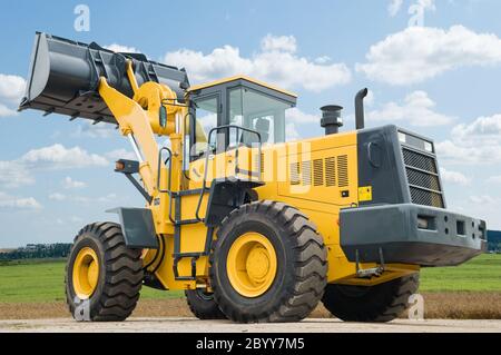 Wheel front-end loader unloading sand into heavy dump truck at the ...