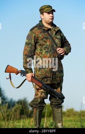 Hunting gun. Hunter aiming rifle in forest. Hunter with shotgun gun on ...
