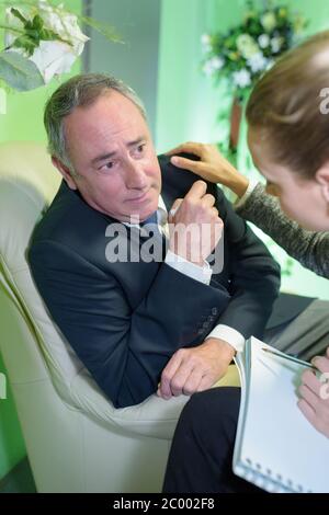 Sad old man with flowers mourning at the graveyard Stock Photo - Alamy