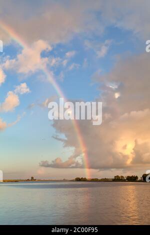 Scenic cloudscape with a rainbow over the lake Stock Photo - Alamy
