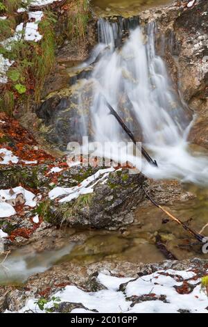 scenic alpine landscape with a waterfall, a transparent alpine lake and ...