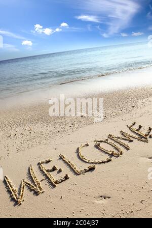 welcome text inscription on the sand shore tropical clear sea Stock ...