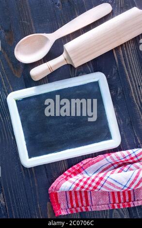 Empty chalk board and kitchen utensils with spices on a white wooden ...