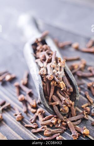 Vintage photo, Heap of brown cloves on wooden spoon lying on jute ...