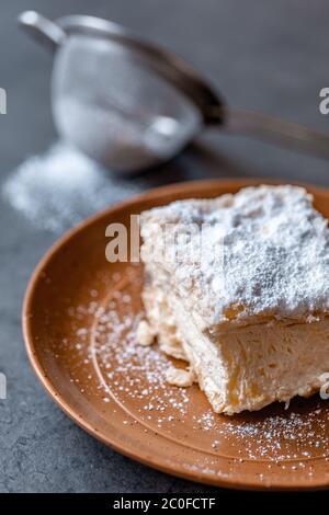 cremeschnitte or cremsnit cake on a square black stone tile texture ...