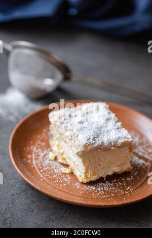 cremeschnitte or cremsnit cake on a square black stone tile texture ...