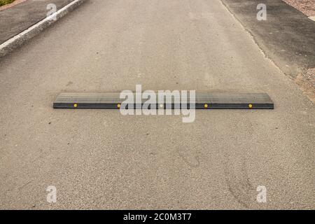 Close up view of speed bump on village street road. Landscape view ...