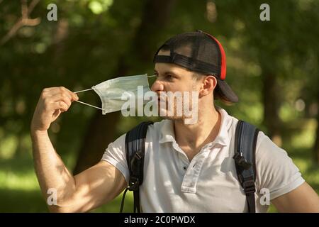 The guy takes off the mask from his face. Walk in the park Stock Photo ...