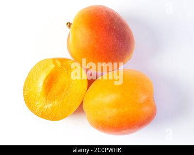 Whole and half fresh apricots on wooden table Stock Photo - Alamy