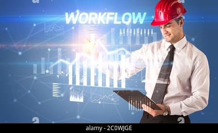 Handsome businessman with helmet drawing WORKFLOW inscription ...