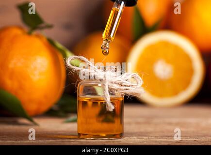 Orange essential oil in glass bottle with green leaf. Cosmetic concept ...