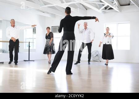 Mixed race dance teacher demonstrating ballroom dancing Stock Photo - Alamy