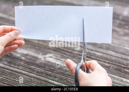 Woman cutting paper with scissors at white wooden table, top view Stock ...