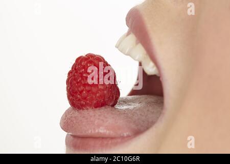 Raspberry on the tongue Stock Photo - Alamy