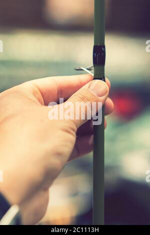 male customer selecting fishing lures near stand in the sports shop ...