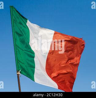 Italian flag blowing in the wind in the blue sky Stock Photo - Alamy