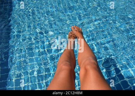 Female legs dipped in water in blue swimming pool Stock Photo - Alamy