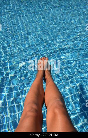 Female legs dipped in a blue swimming pool Stock Photo - Alamy