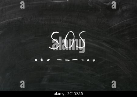 SOS word handwritten with white chalk on a blackboard Stock Photo - Alamy