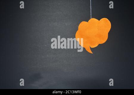 orange call out hanging with some parts in focus against black ...